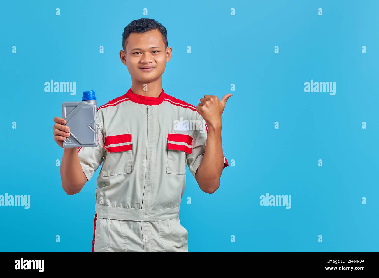 Portrait of smiling young Asian mechanic showing engine oil plastic ...