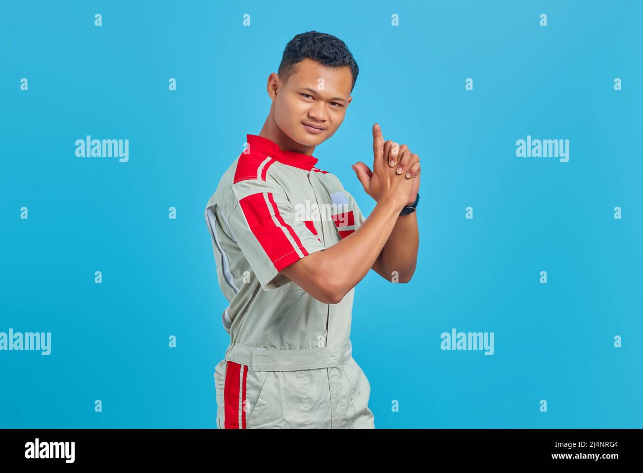Portrait of young Asian mechanic holding symbolic weapon with hand ...