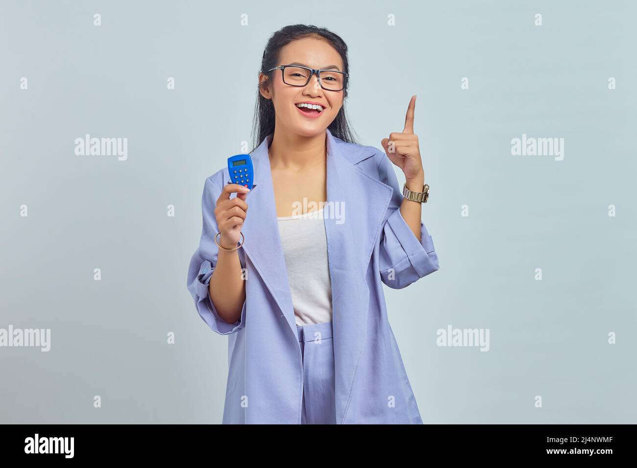 Portrait of cheerful young Asian woman holding banking token and ...