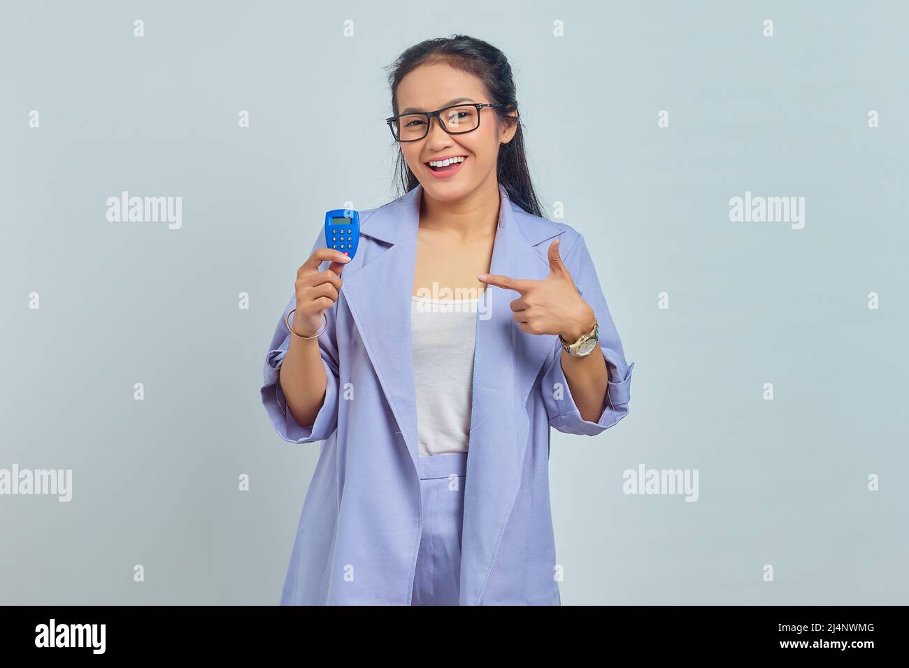 Portrait of cheerful young Asian woman pointing finger at banking token ...
