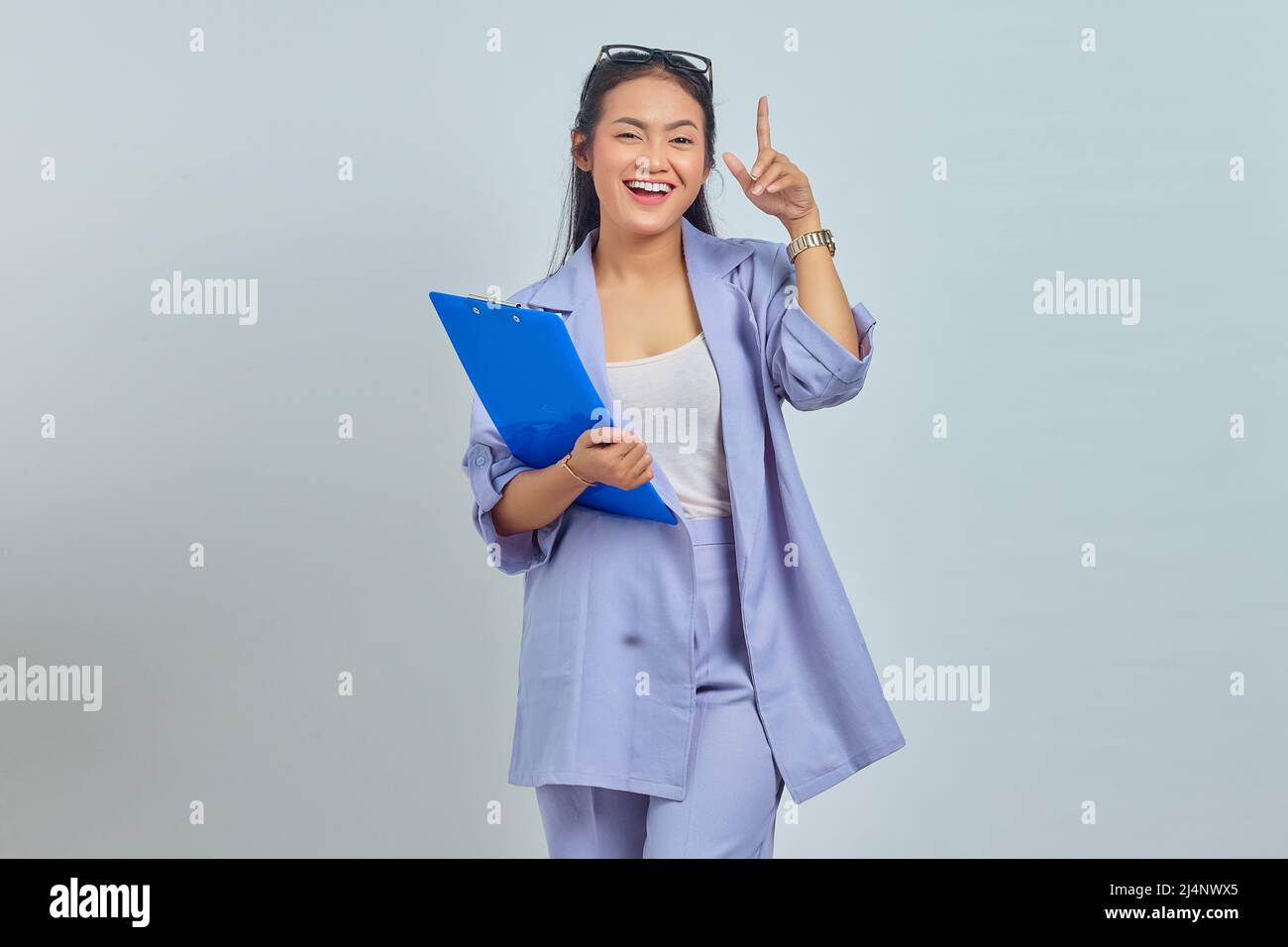 Portrait of satisfied young asian woman promoting above product ...