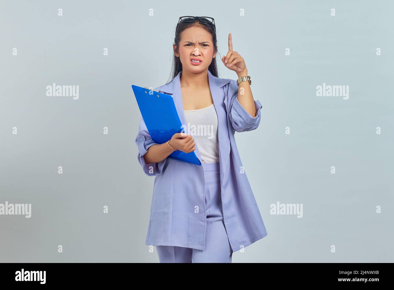 Portrait of angry young Asian woman holding document folder and ...