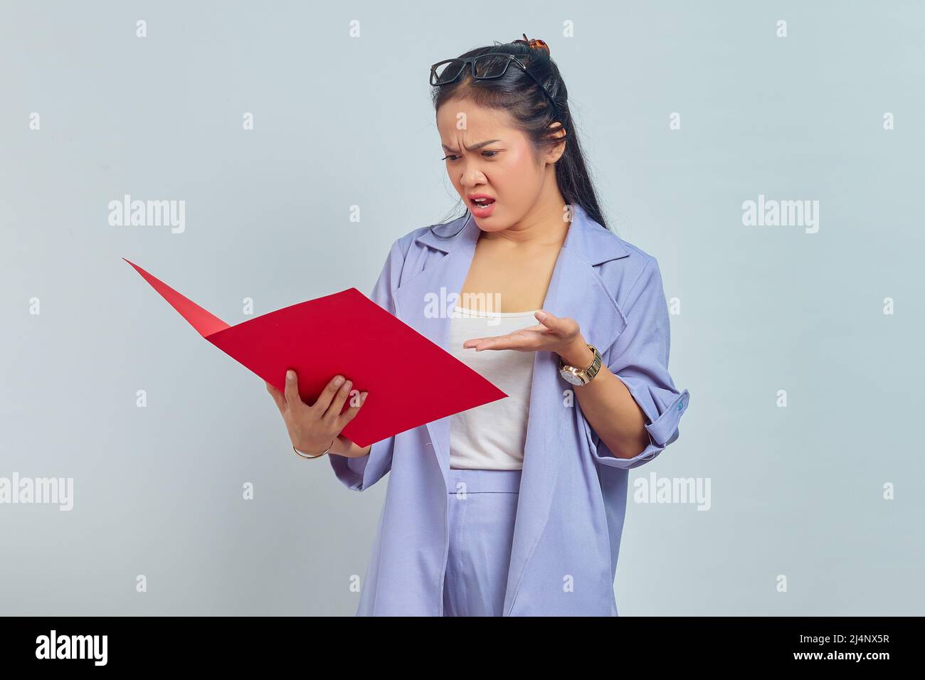 Portrait of angry young Asian business woman in suit standing pointing ...