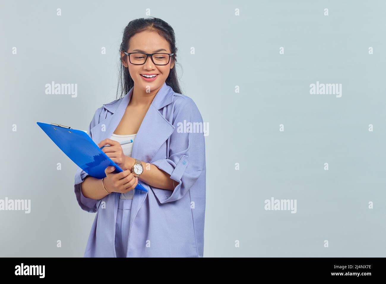 Portrait of beautiful young Asian business woman in suit standing ...