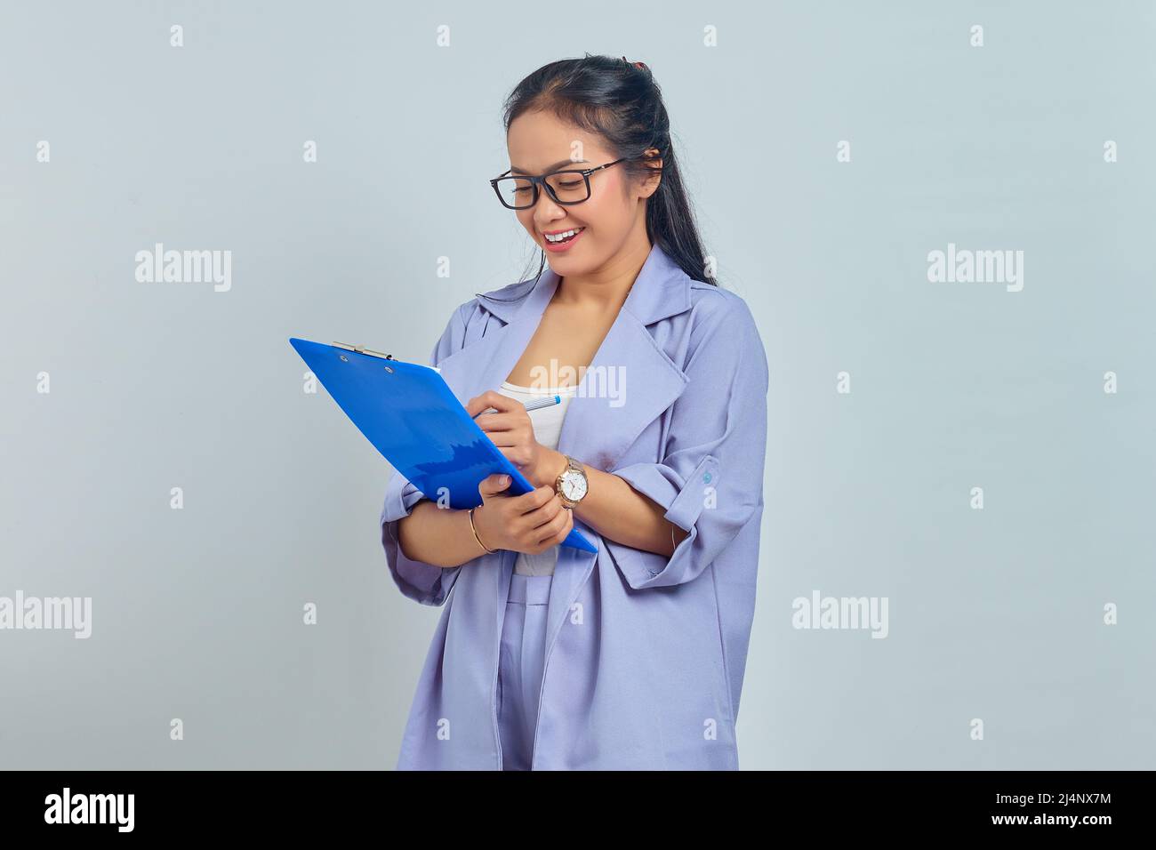 Portrait of beautiful young Asian business woman in suit standing ...