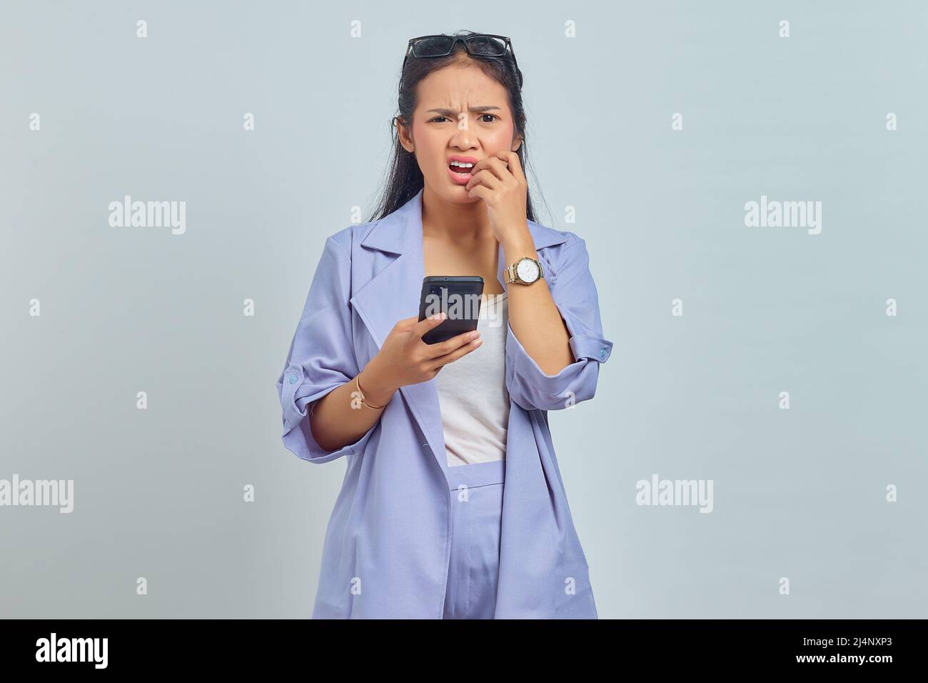 Portrait of young Asian woman using cell phone looking stressed and ...