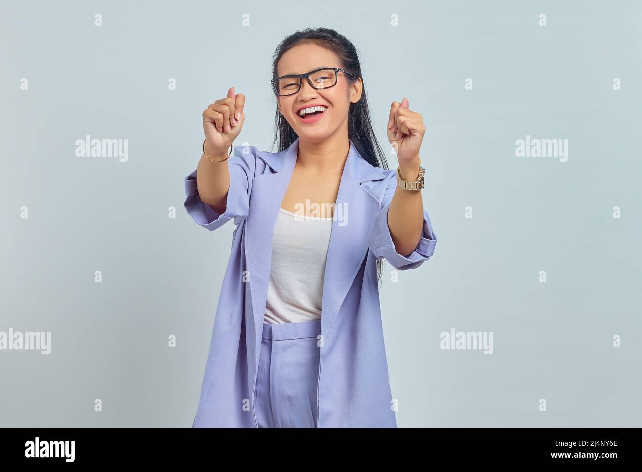 Portrait of smiling young asian woman showing korean heart sign with ...
