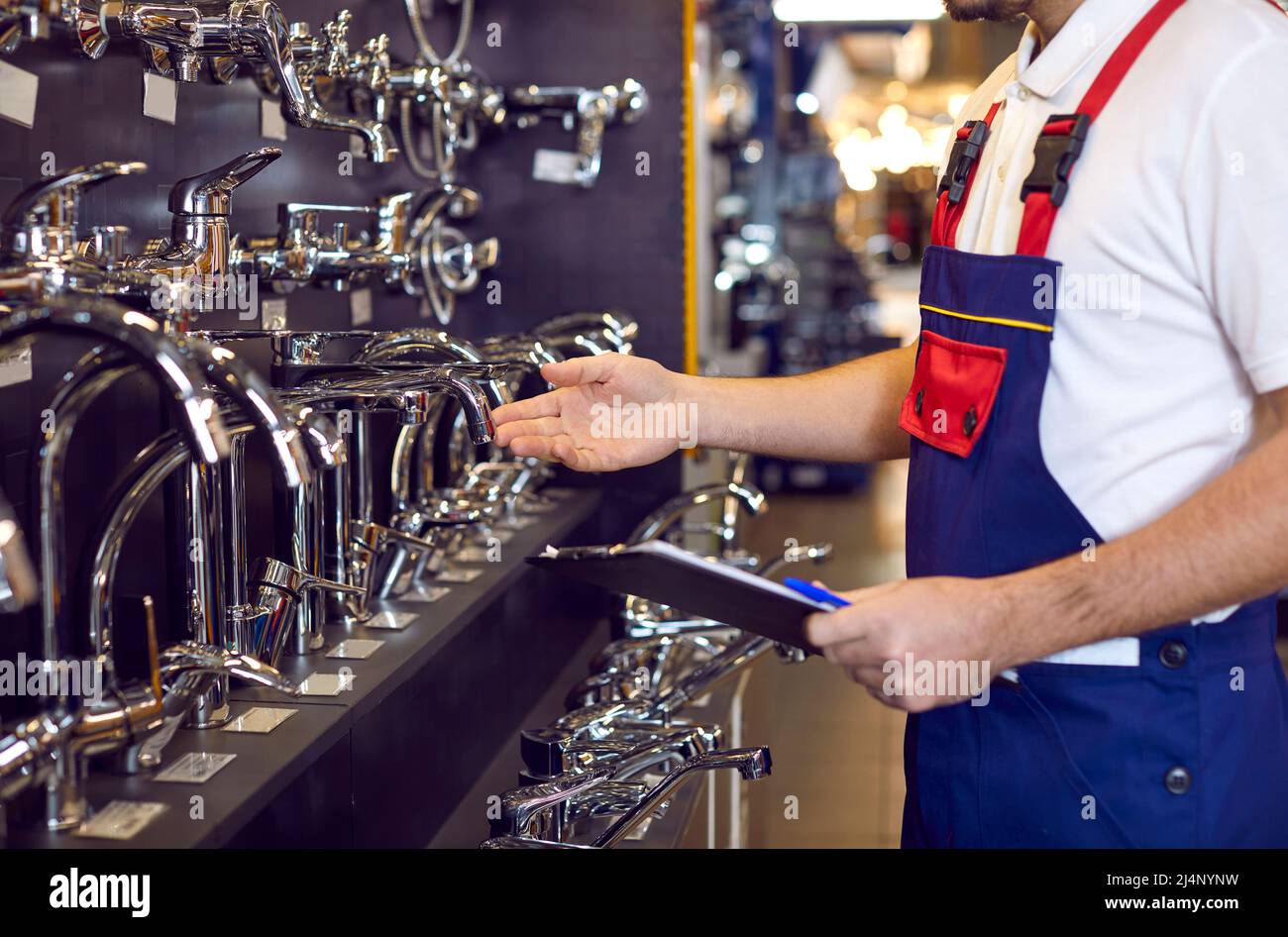 Male worker checks assortment on showcase with stainless steel water ...