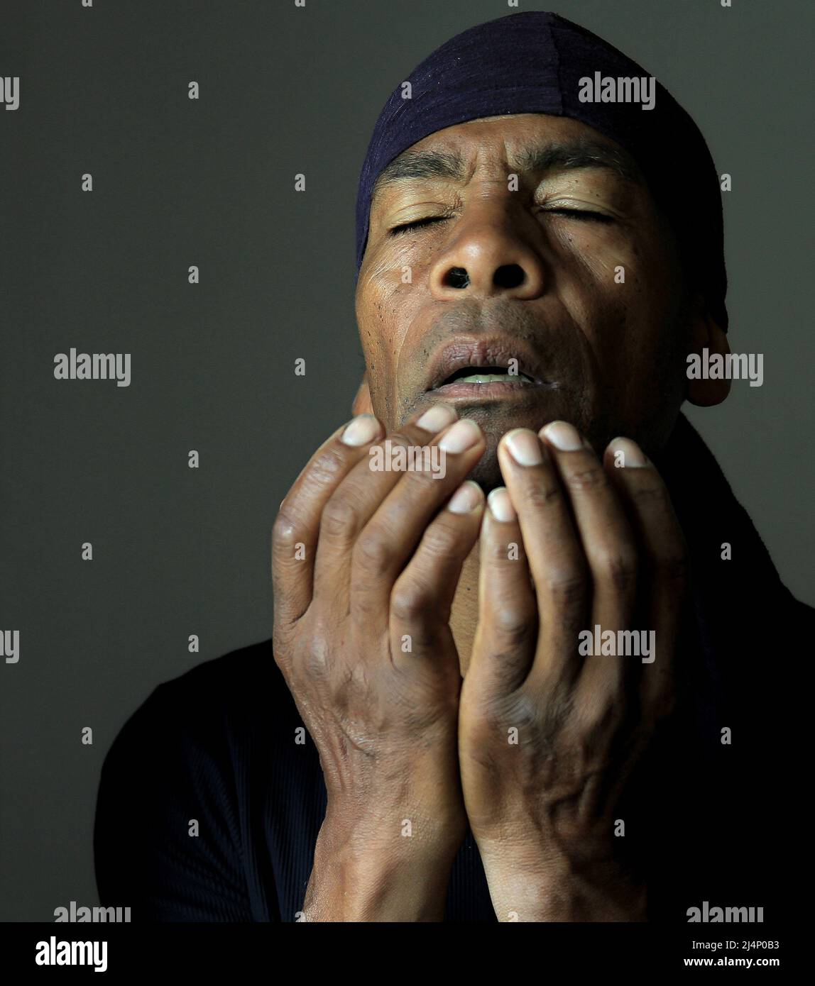 man praying to god with hands together stock photo Stock Photo - Alamy