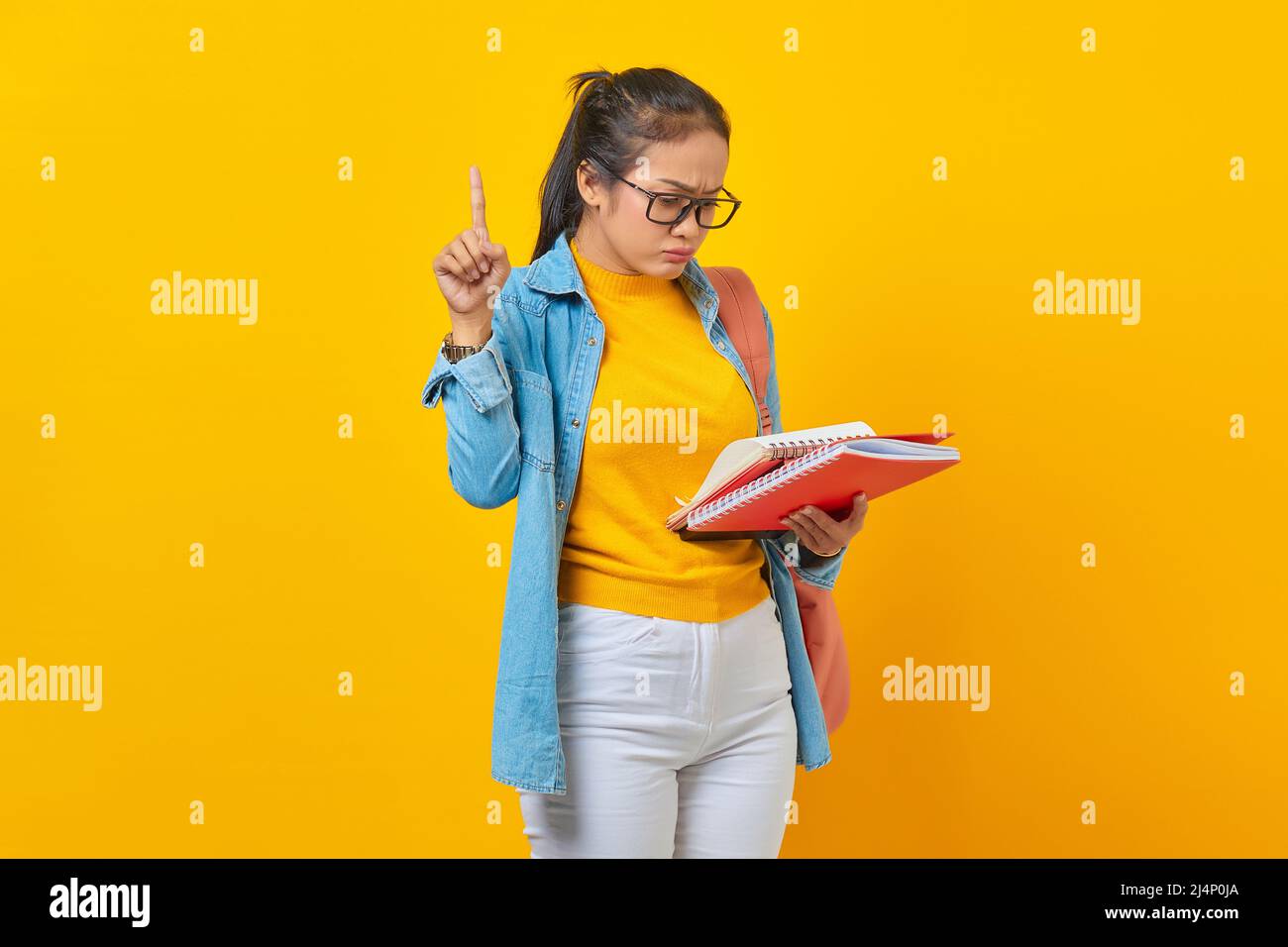 Young woman student in denim clothes with backpack, Holding book ...