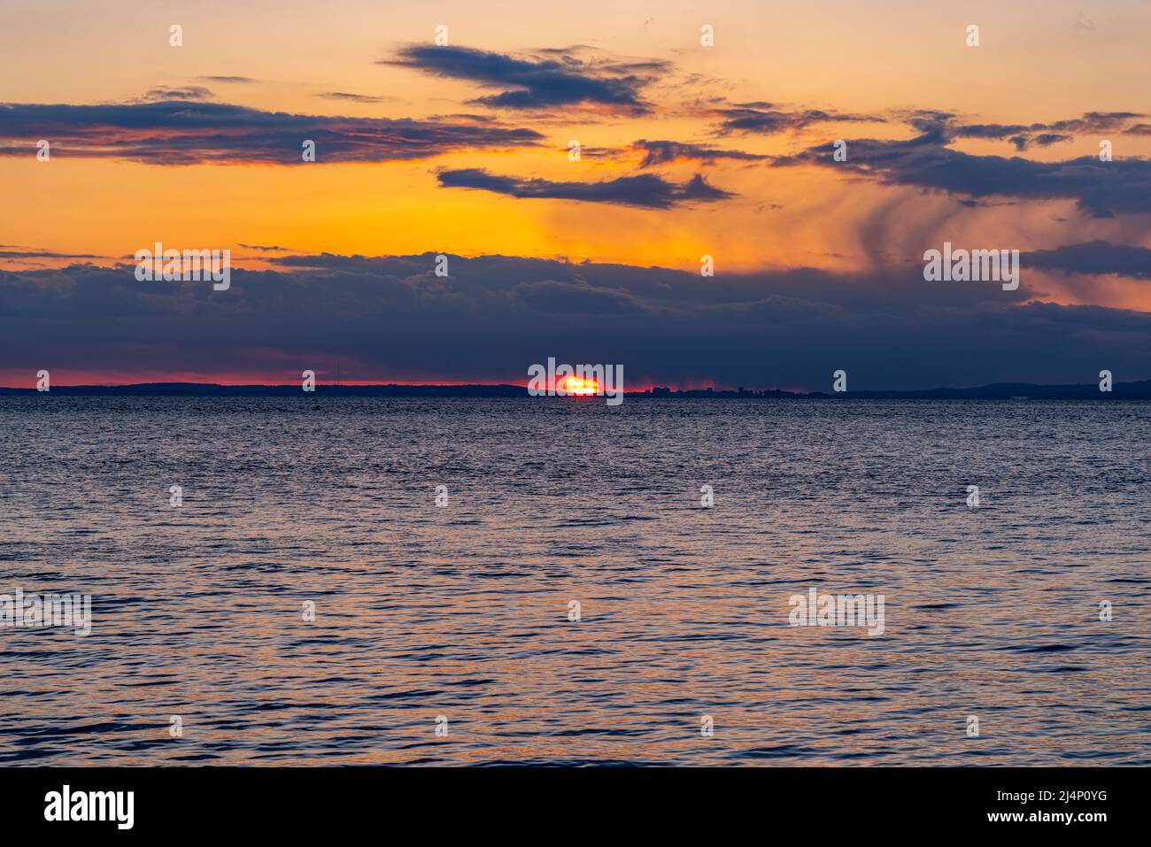 The sun about to disappear over the horizon Stock Photo - Alamy