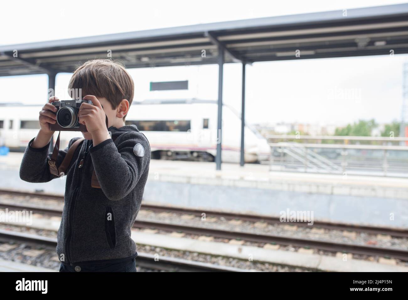 Child boy taking pictures at railway station. Travel on train with ...
