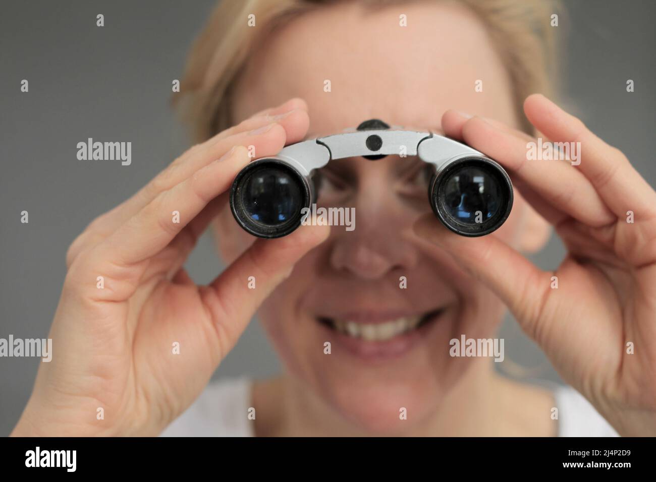 looking through binoculars on grey black background with people stock ...