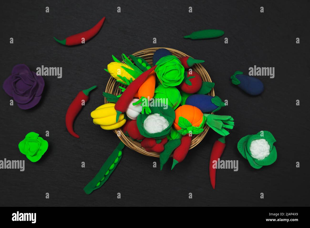 Basket of plasticine vegetables and fruits on a black background. Fresh ...