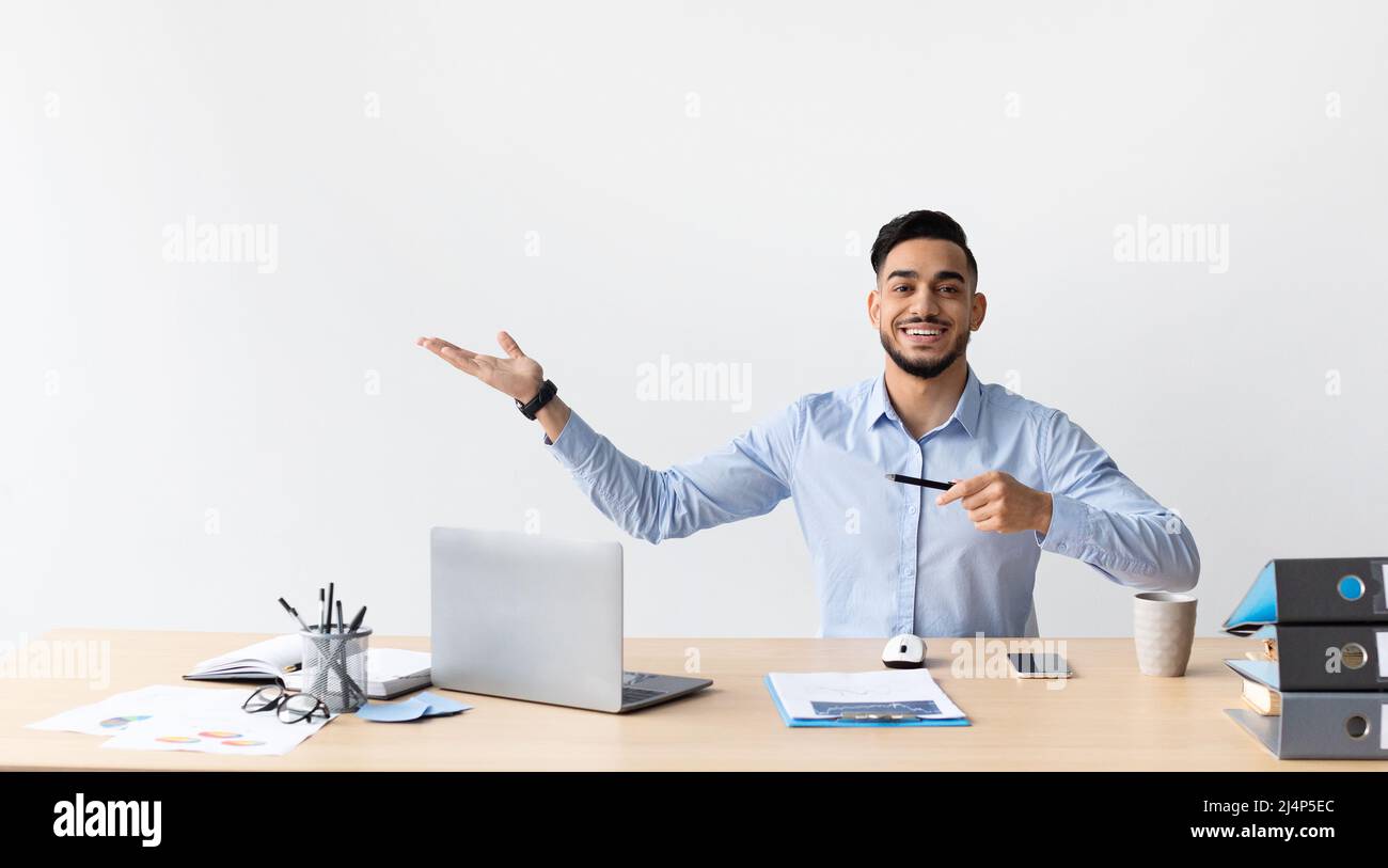 Happy Business Man Pointing Aside Sitting At Workplace Stock Photo - Alamy