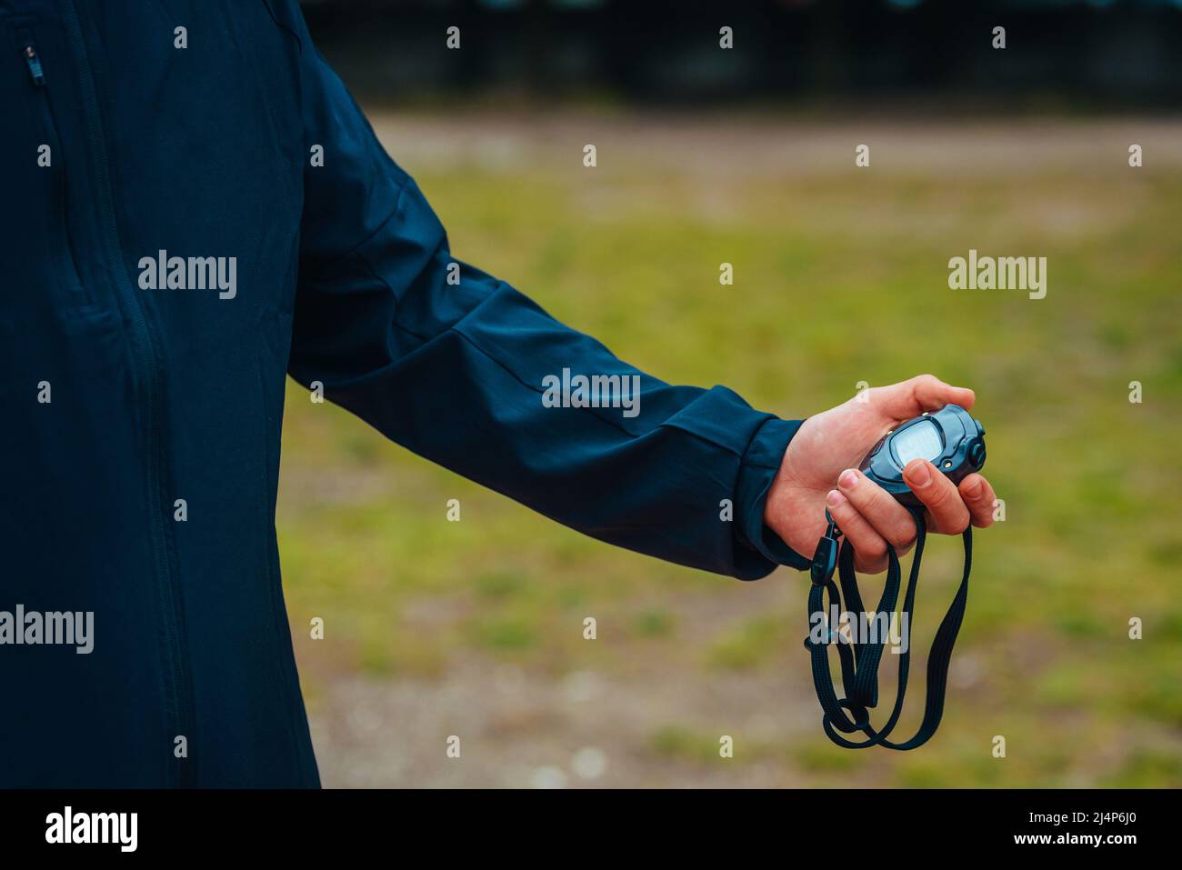 The running trainer holds a stopwatch in his hands and measures the ...