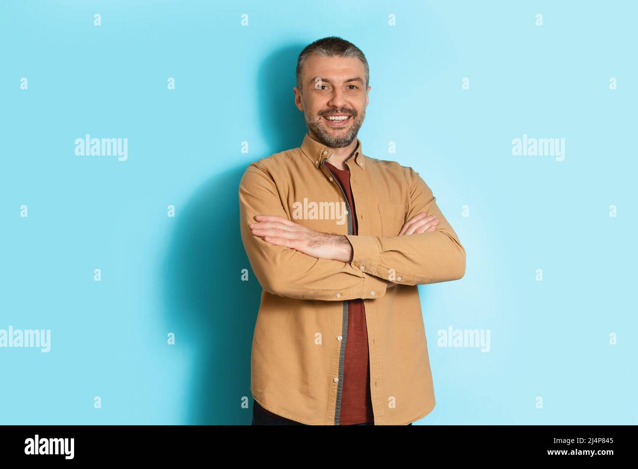 Happy Middle Aged Man Standing Crossing Hands Over Blue Background ...