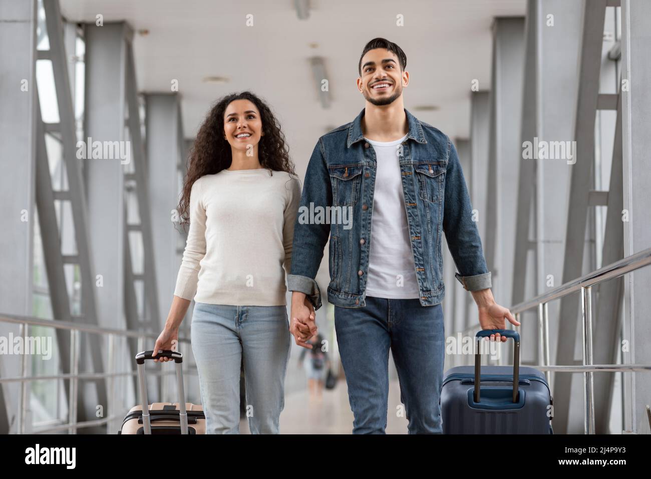 Portrait Of Positive Millennial Arab Couple Walking At Airport With ...