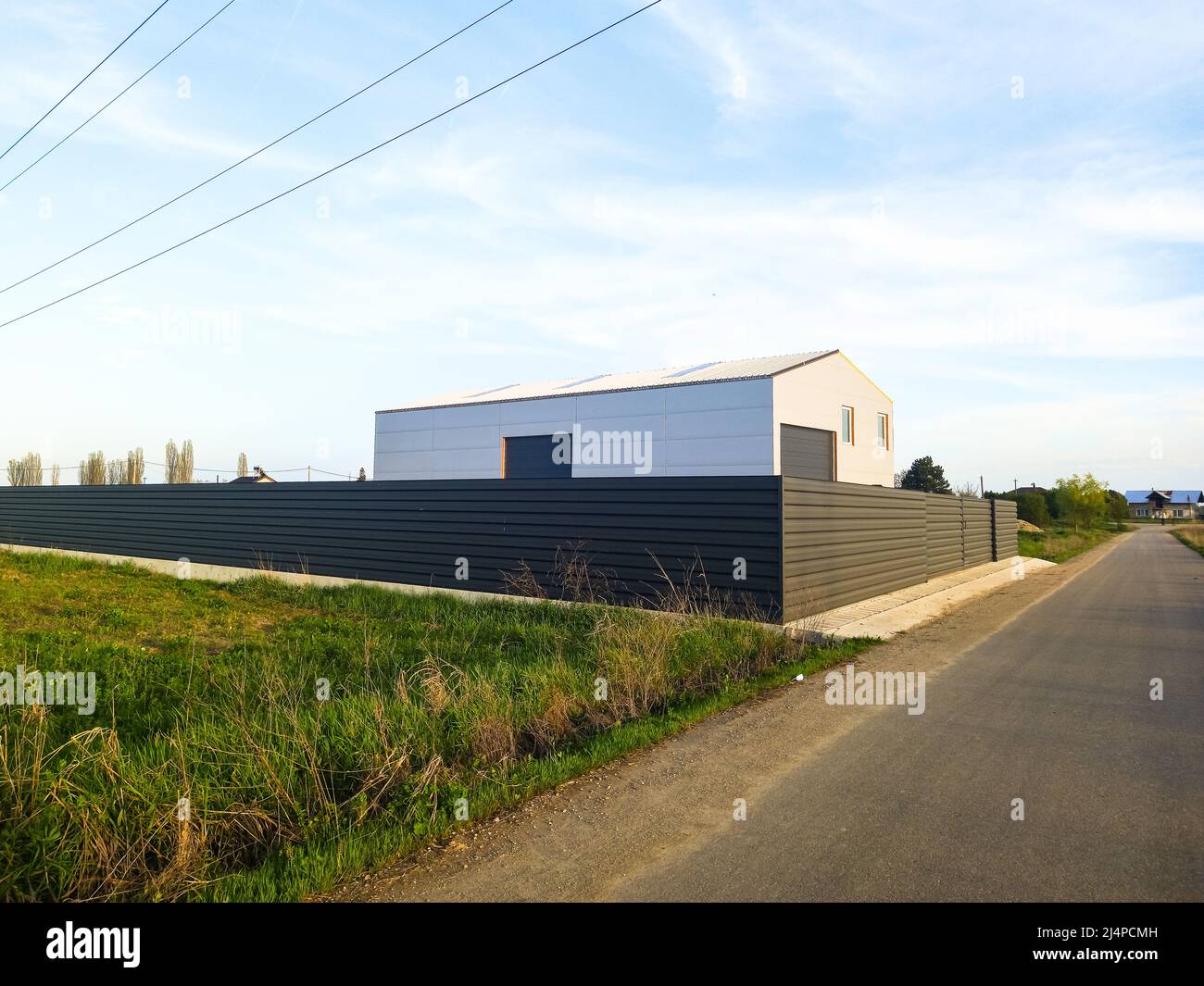 Warehouse building with fence. Industrial warehouse Stock Photo - Alamy