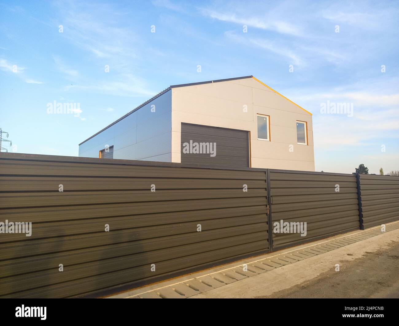 Warehouse building with fence. Industrial warehouse Stock Photo - Alamy