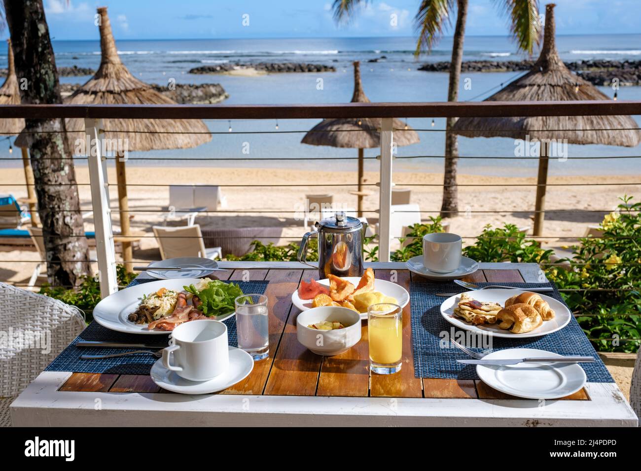 breakfast at a beach with palm trees and a pool in Mauritius, a ...