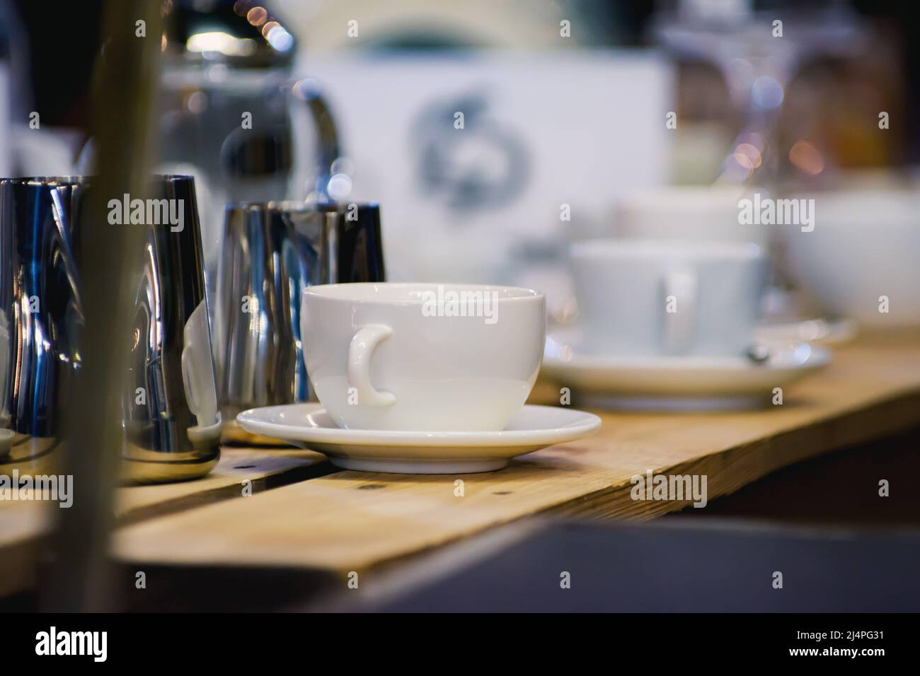 Two white porcelain cups for coffee on a wooden table. Shallow depth of ...