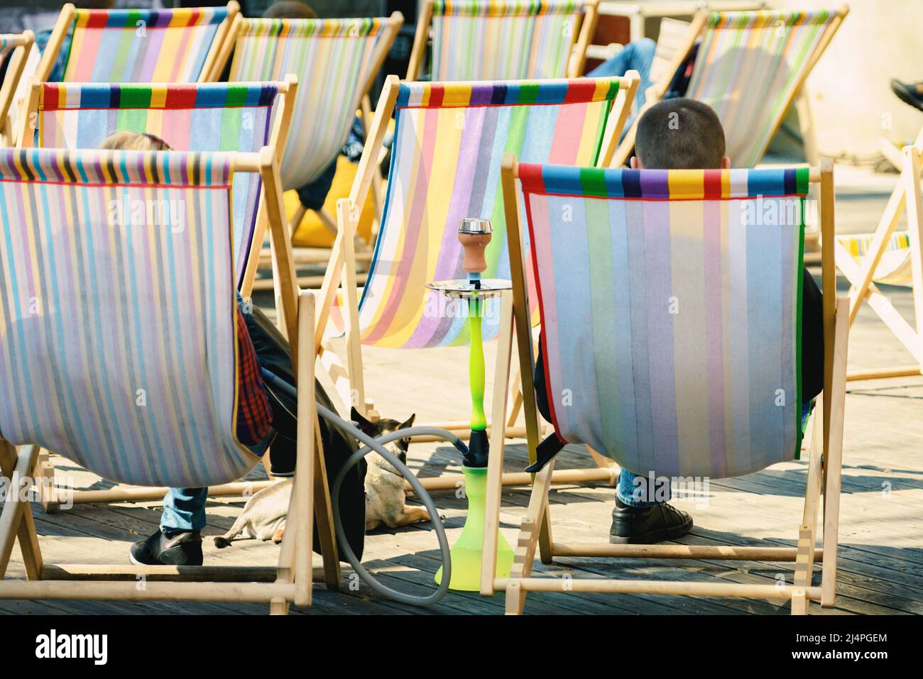 People are smoking a hookah sitting in a chair.Focus on hookah Stock ...