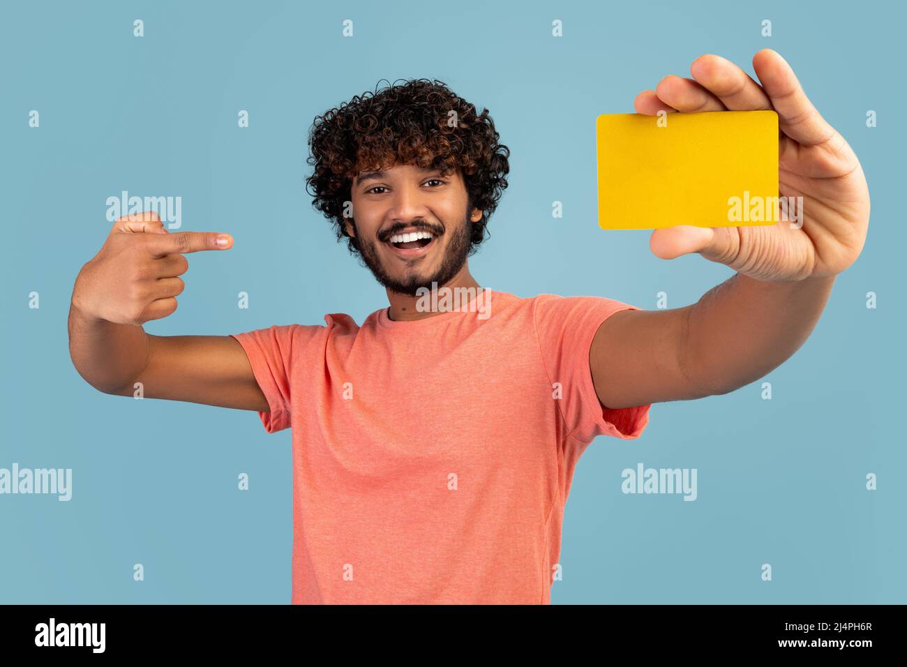 Cheerful young indian man pointing at credit card Stock Photo - Alamy