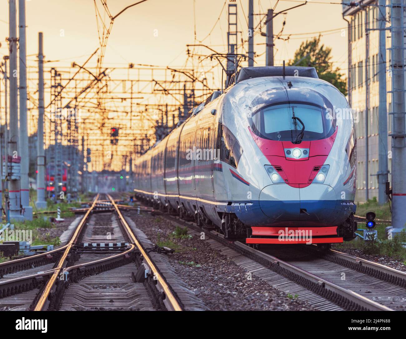 Passenger train approaches to the platform at sunset Stock Photo - Alamy