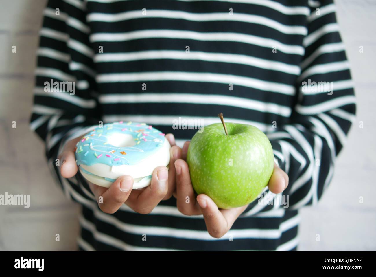 teenage boy hand holding donuts and apple Stock Photo - Alamy