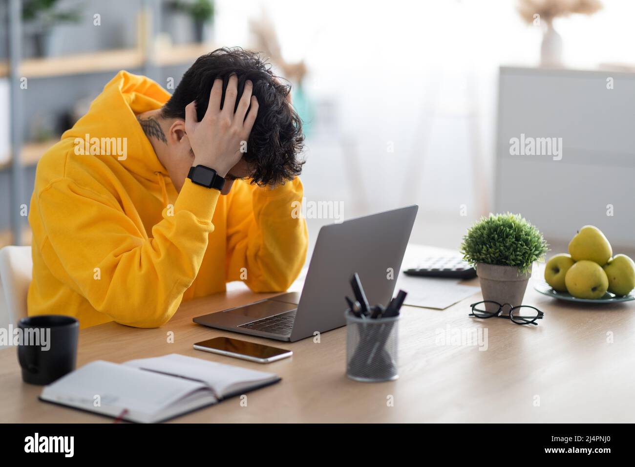 Stressed Asian male sitting at desk using pc grabbing head Stock Photo ...