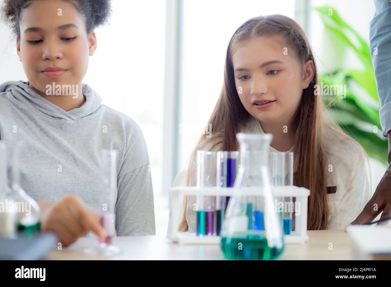 Young teacher teaching group student about science and test chemical ...