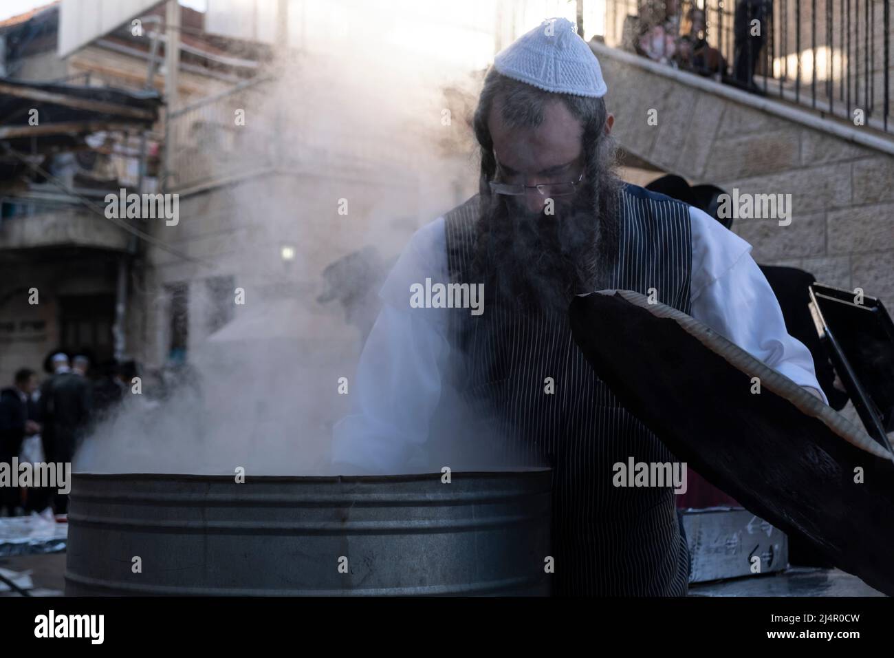 An Ultra-Orthodox Jew dips cooking utensils in boiling water in a ...
