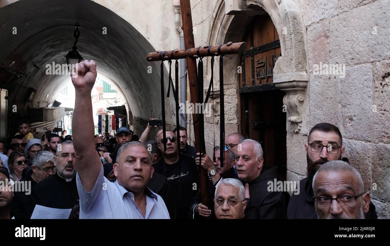 Christian Arab worshipers hold a large wooden cross at the 6th station ...