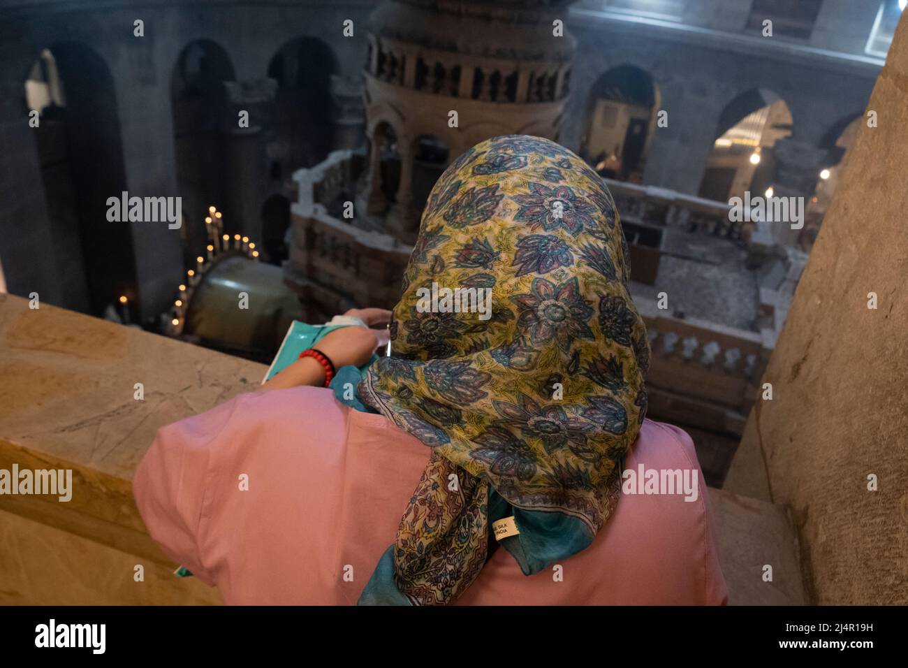 A Christian worshipers looks downward at the Edicule, the shrine that ...