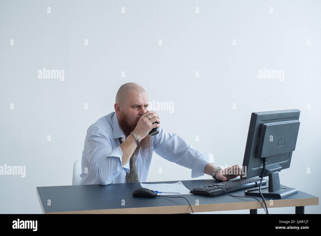 Problems for the office worker. A bald man in a white shirt sits at a ...