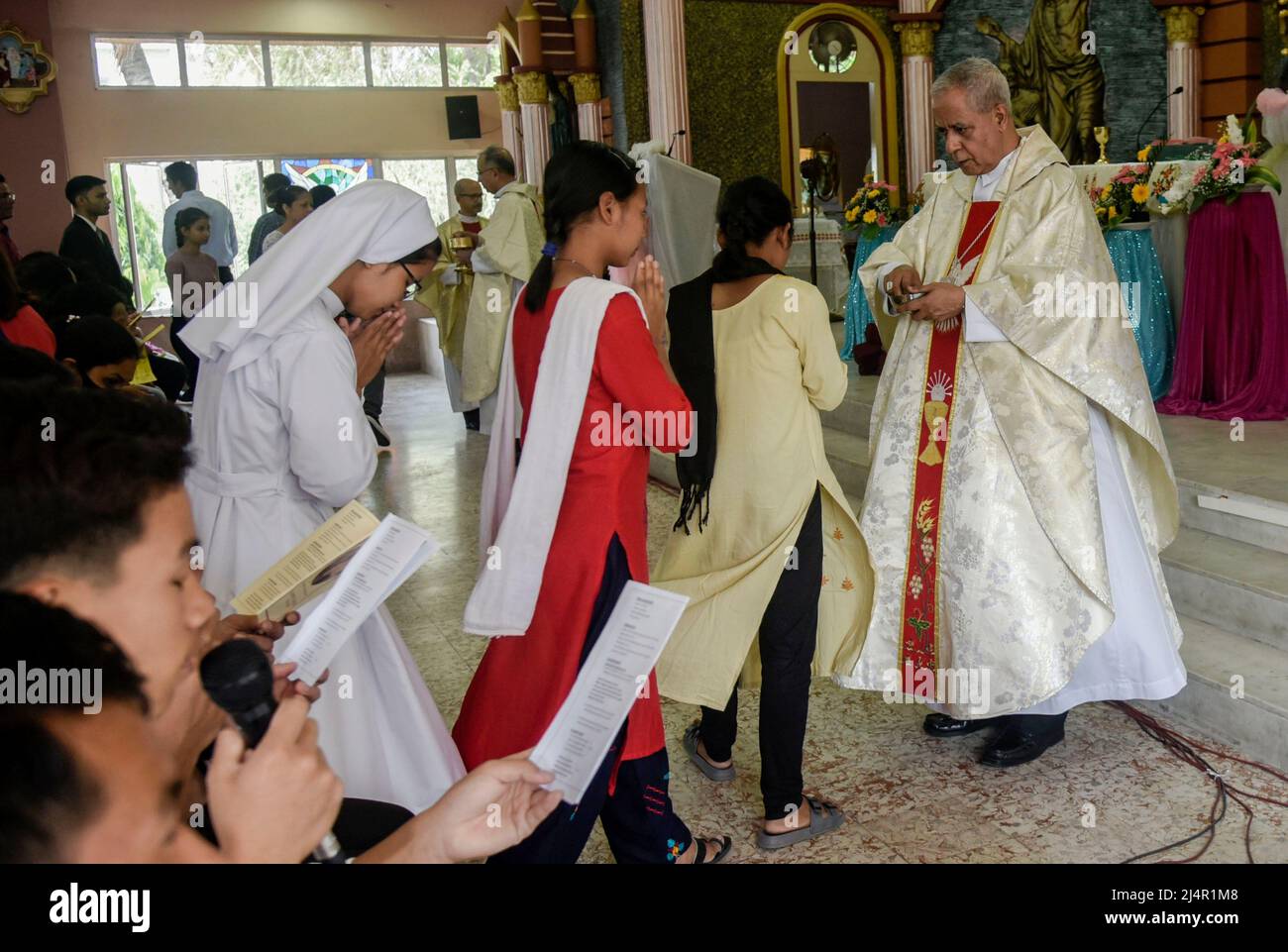 Guwahati, India. 17th Apr, 2022. Priest offers holy communion to ...