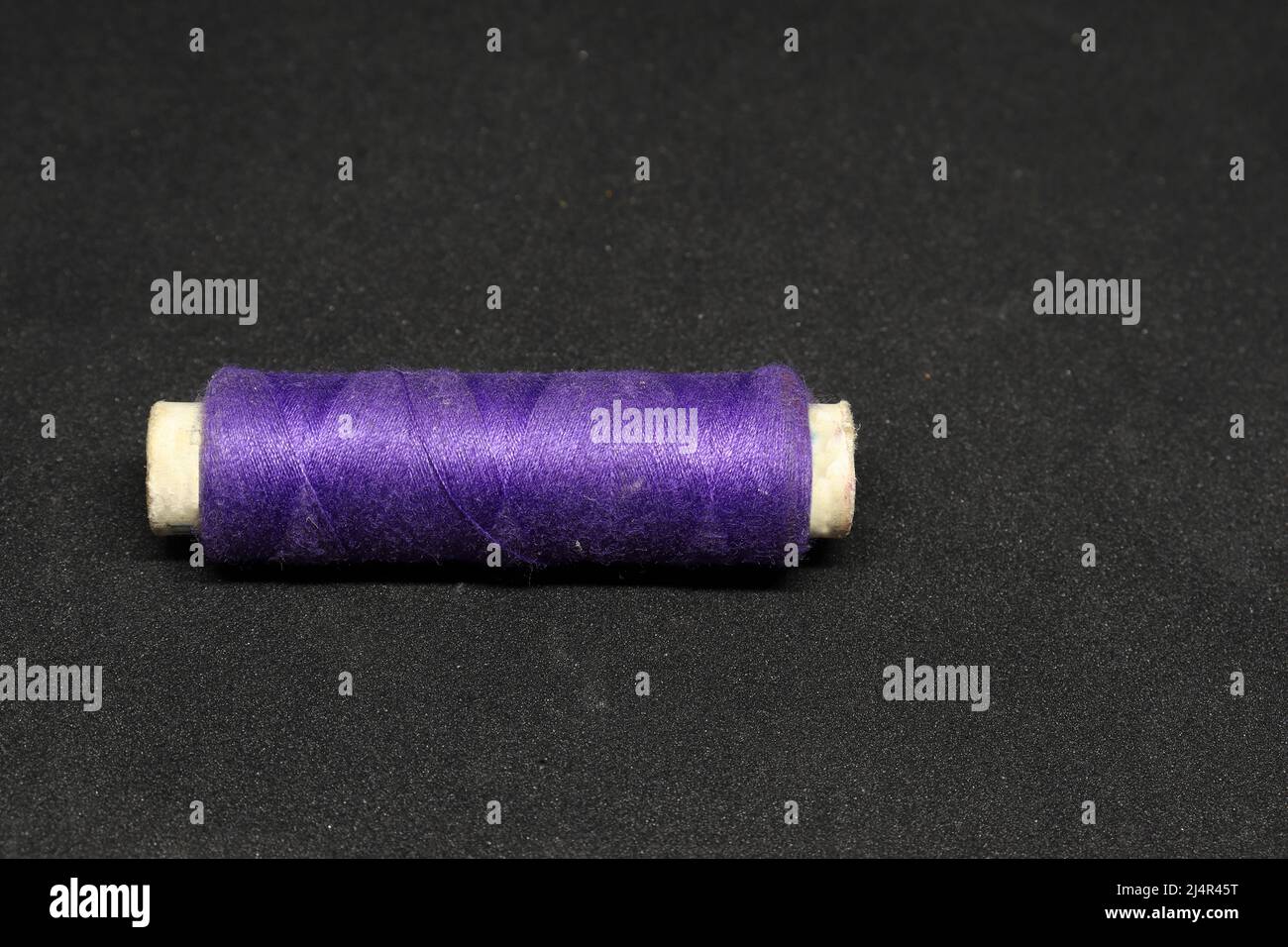 purple color thread. on a black background Stock Photo - Alamy