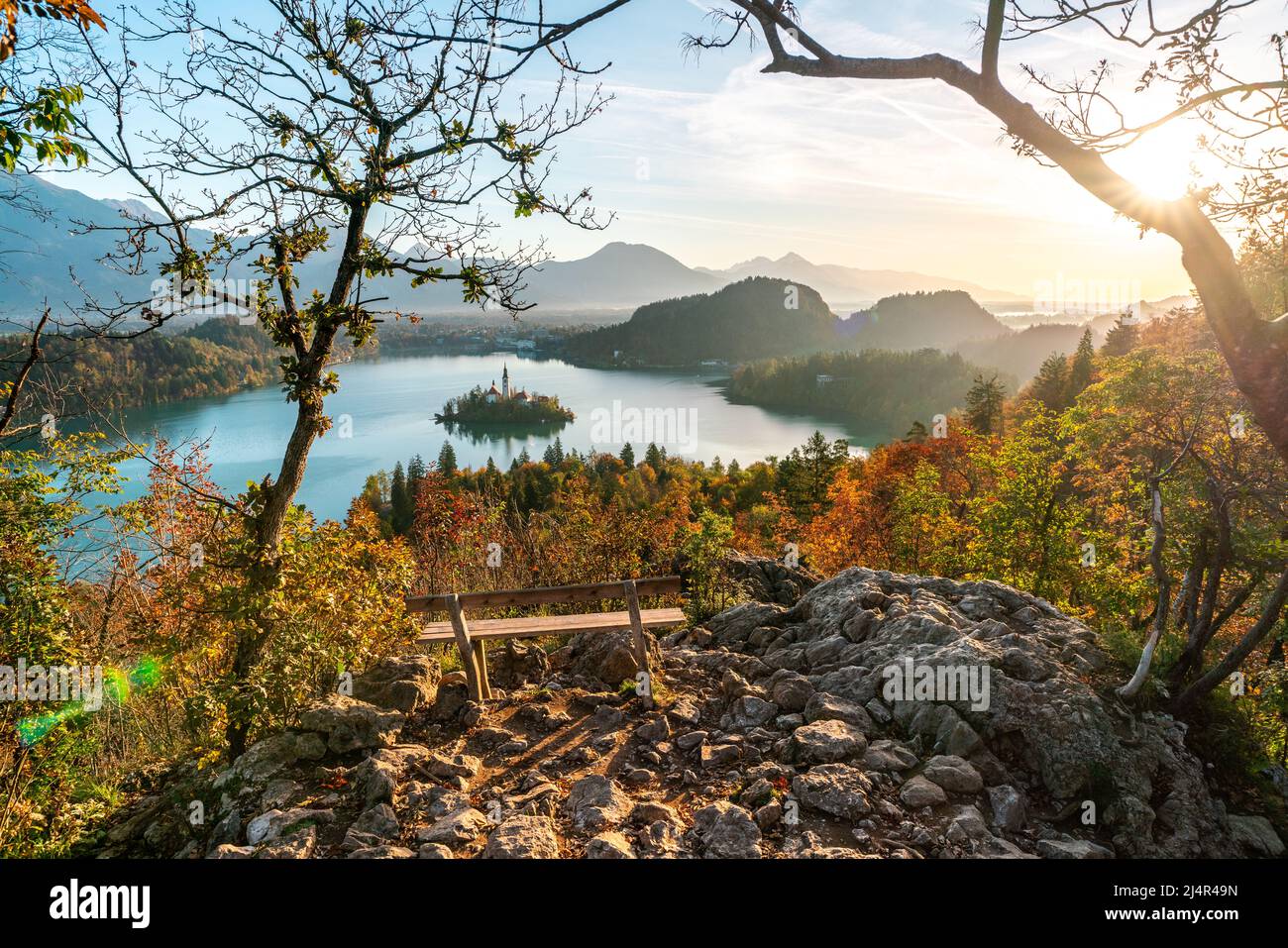 Amazing view of Lake Bled on an autumn morning with a wooden bench in ...