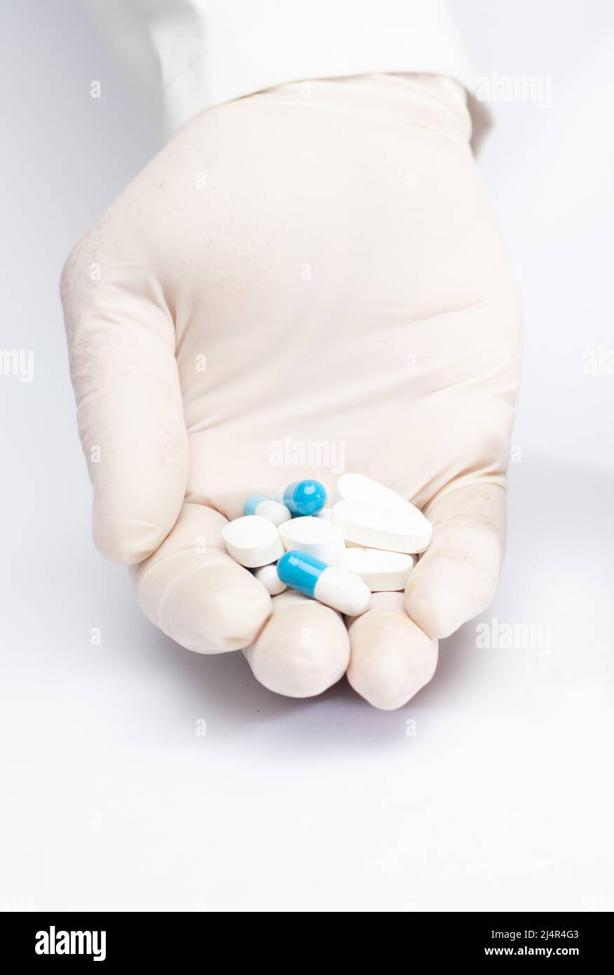 doctor's hand with gloves shows medication capsules Stock Photo - Alamy