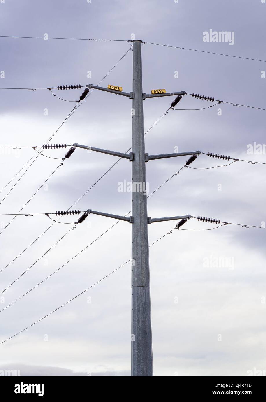 A large steel power pole standing high in the sky holding utility and ...