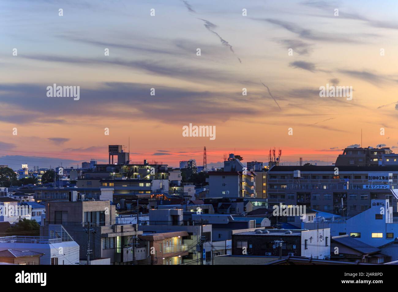 Sunset and clouds over lights of sprawling residential neighborhood ...