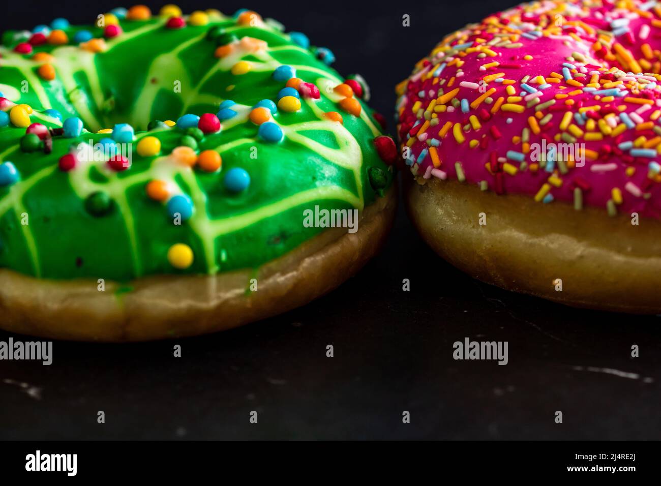 Glazed donuts with sprinkles isolated. Close up of colorful donuts ...