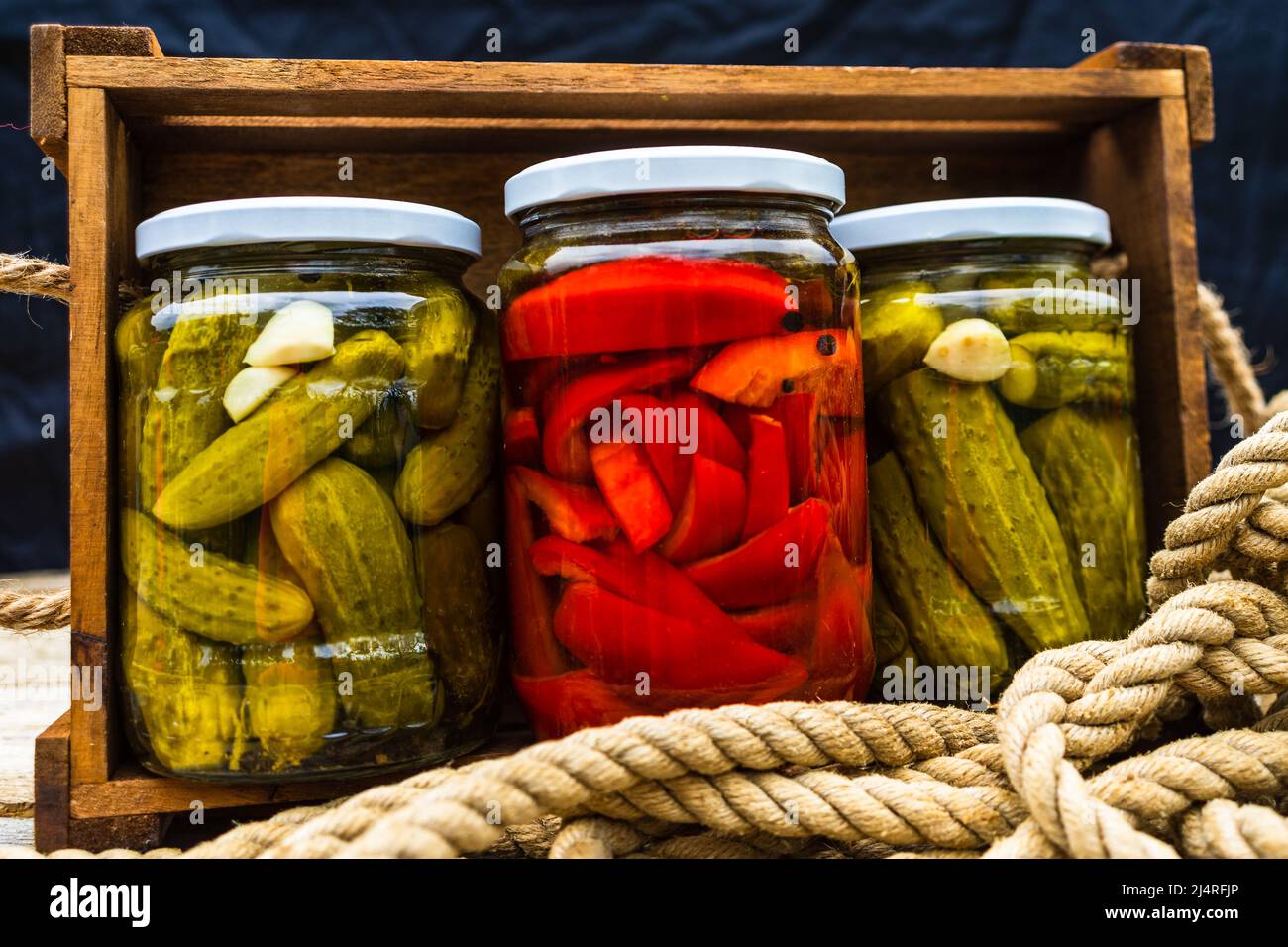 Glass jars with pickled red bell peppers and pickled cucumbers (pickles ...