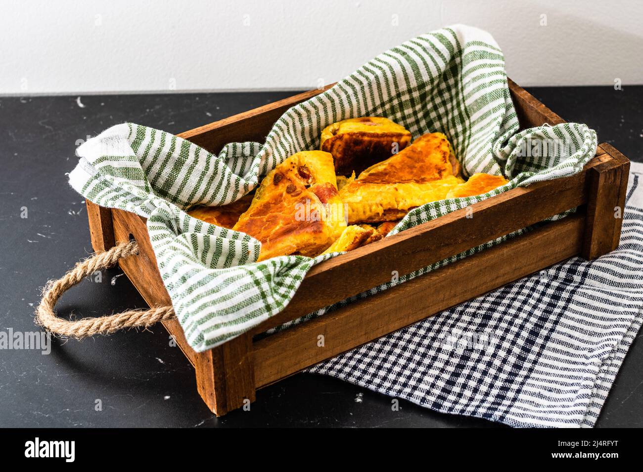 Freshly baked homemade ham and cheese puff pastry in a rustic crate ...