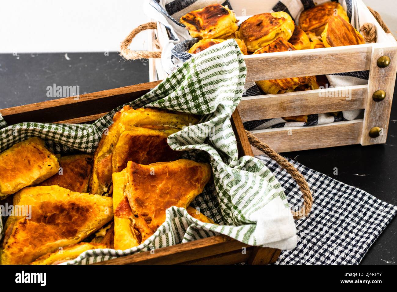 Freshly baked homemade ham and cheese puff pastry in a rustic crate ...