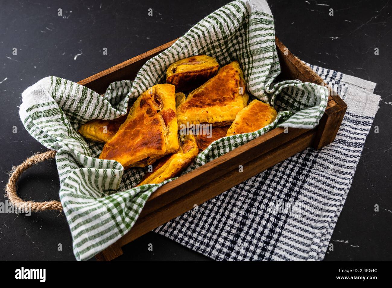Freshly baked homemade ham and cheese puff pastry in a rustic crate ...