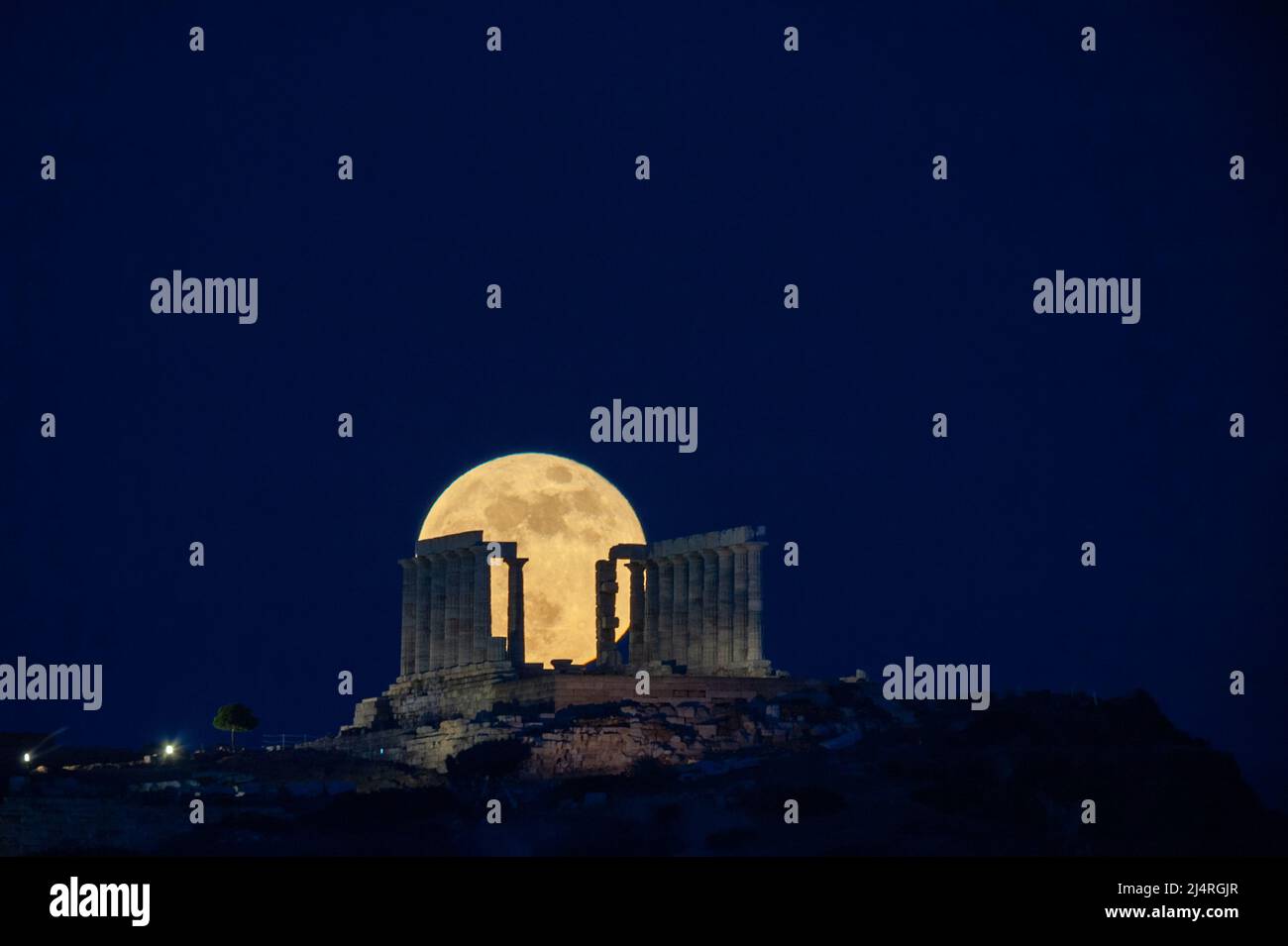 A full moon rises behind the Temple of Poseidon at Cape Sounion, Greece ...