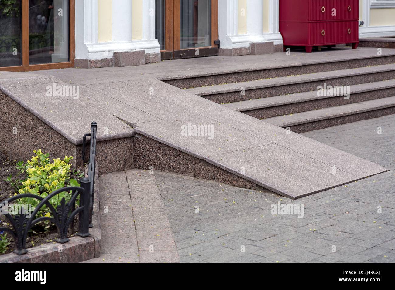 Ramped access, using wheelchair ramp for disabled people. Concrete ramp ...