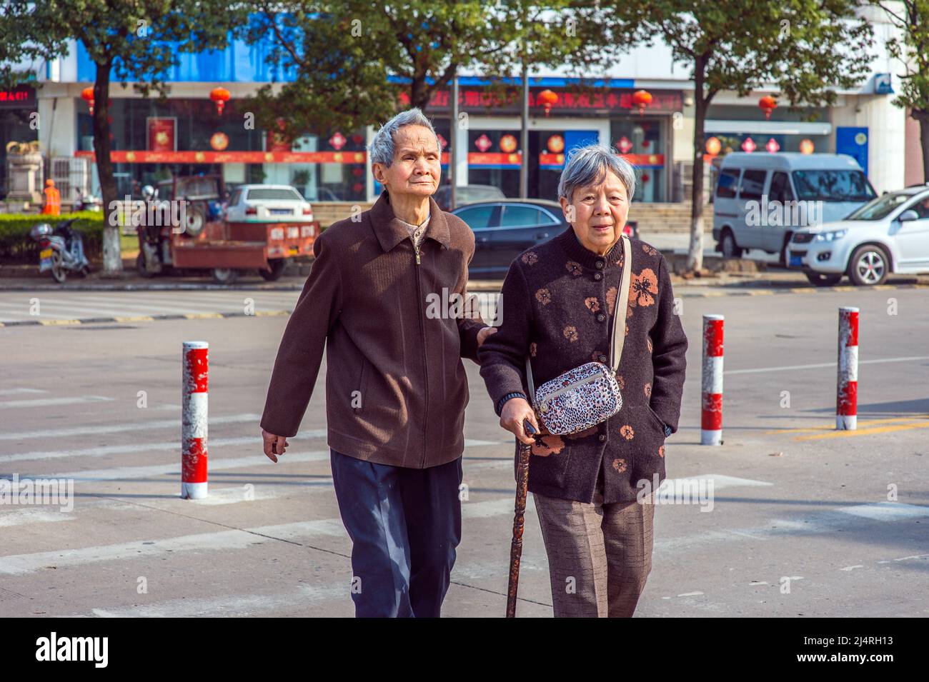 ANQING, CHINA - MARCH 21: Senior Man and Woman walk crossing Street. A ...